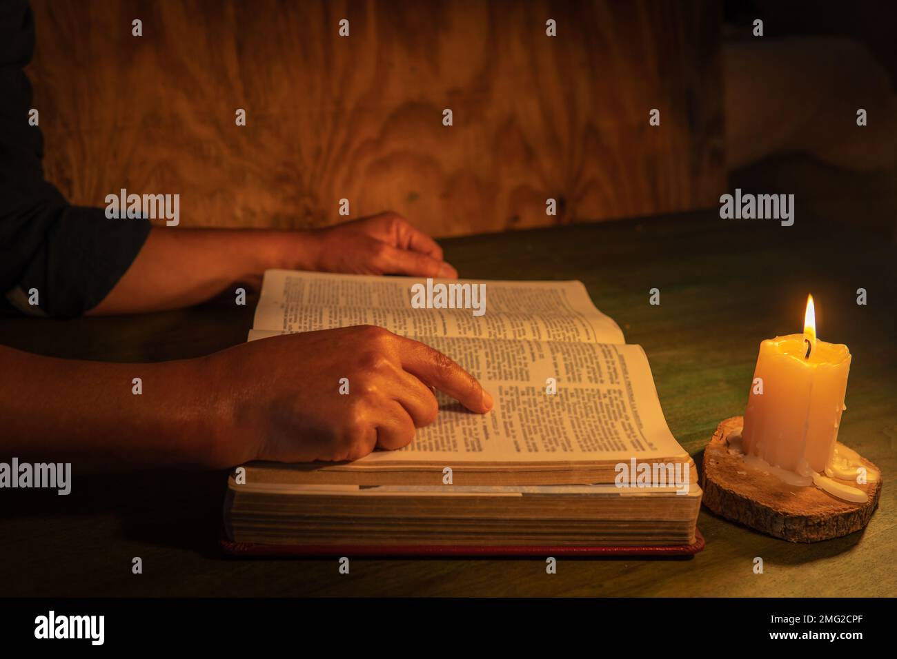 Hands of a man studying the bible pointing to a biblical passage by ...