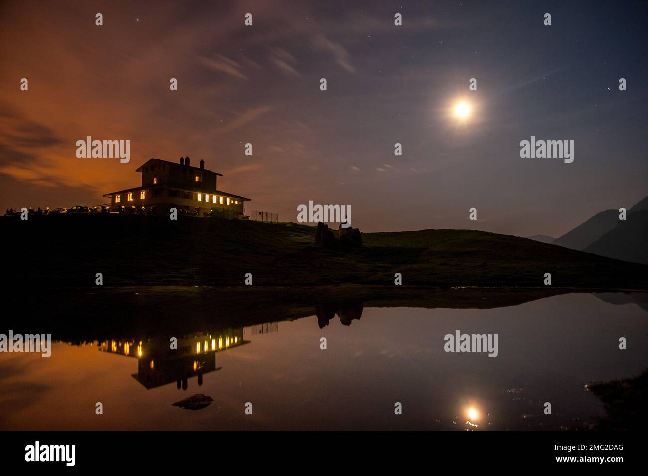 Mountain hut at night reflecting in the lake Stock Photo - Alamy
