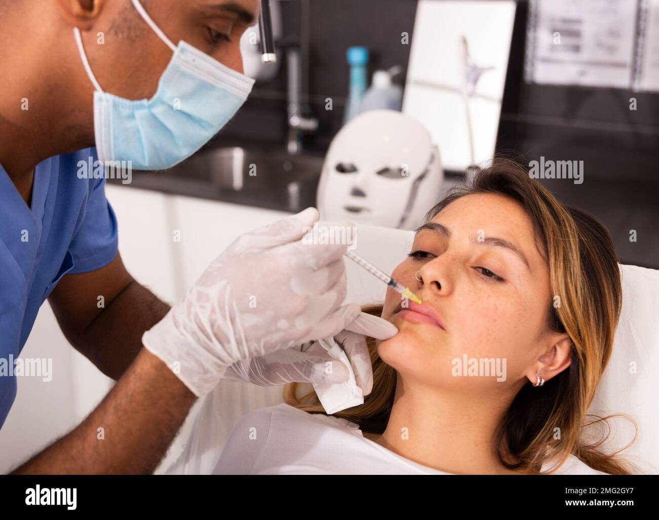 Female client during procedure of face mesotherapy in cosmetology ...