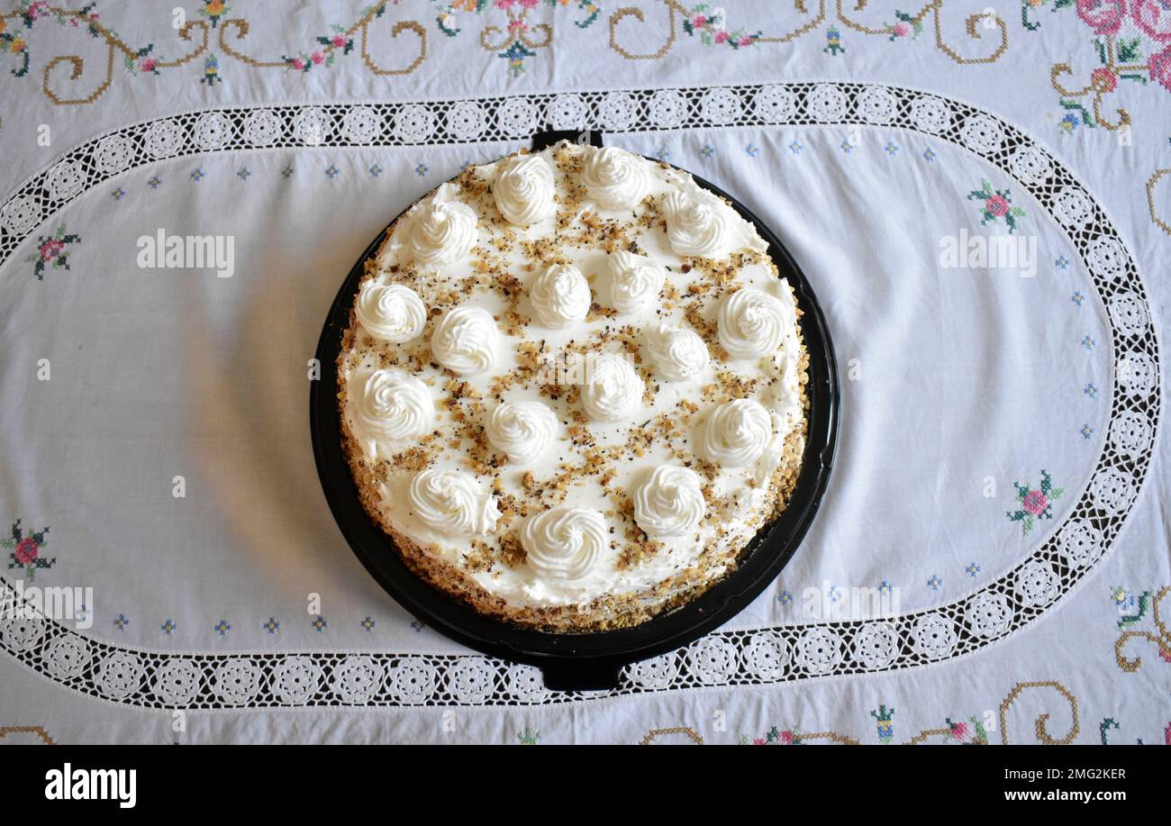 Birthday cake decorating with white whipped cream roses on a colorful ...