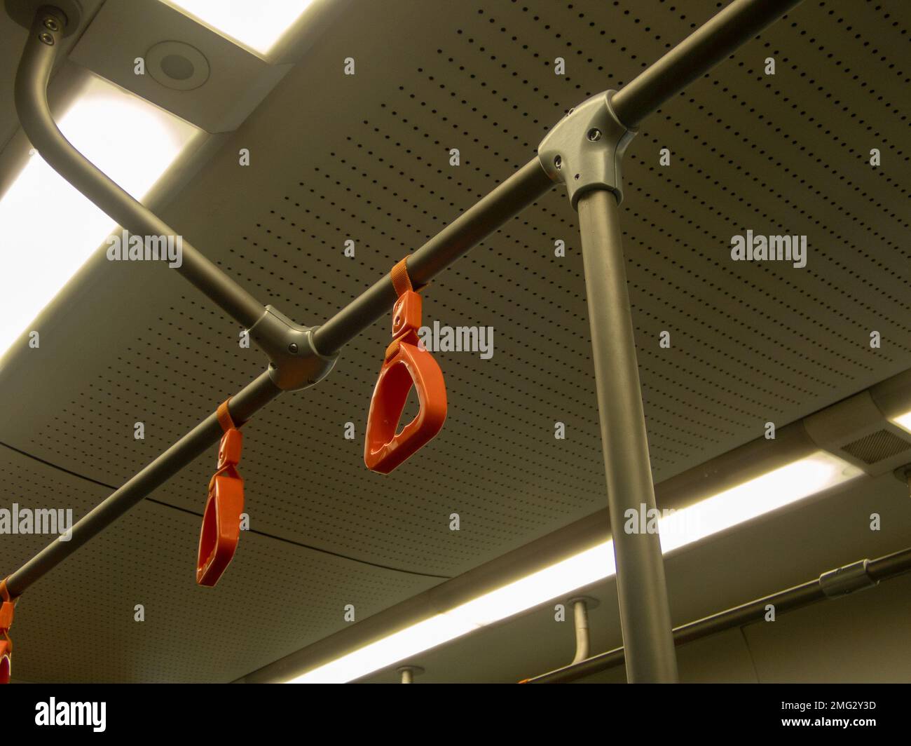 A handle on the ceiling of a bus or train. Underground rail system or ...