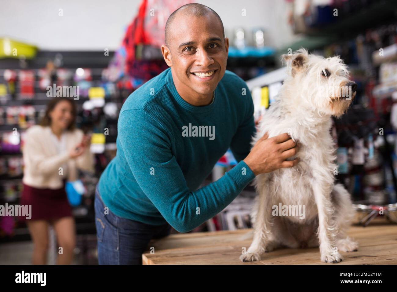 Emotional man hugging dog in pet store Stock Photo - Alamy