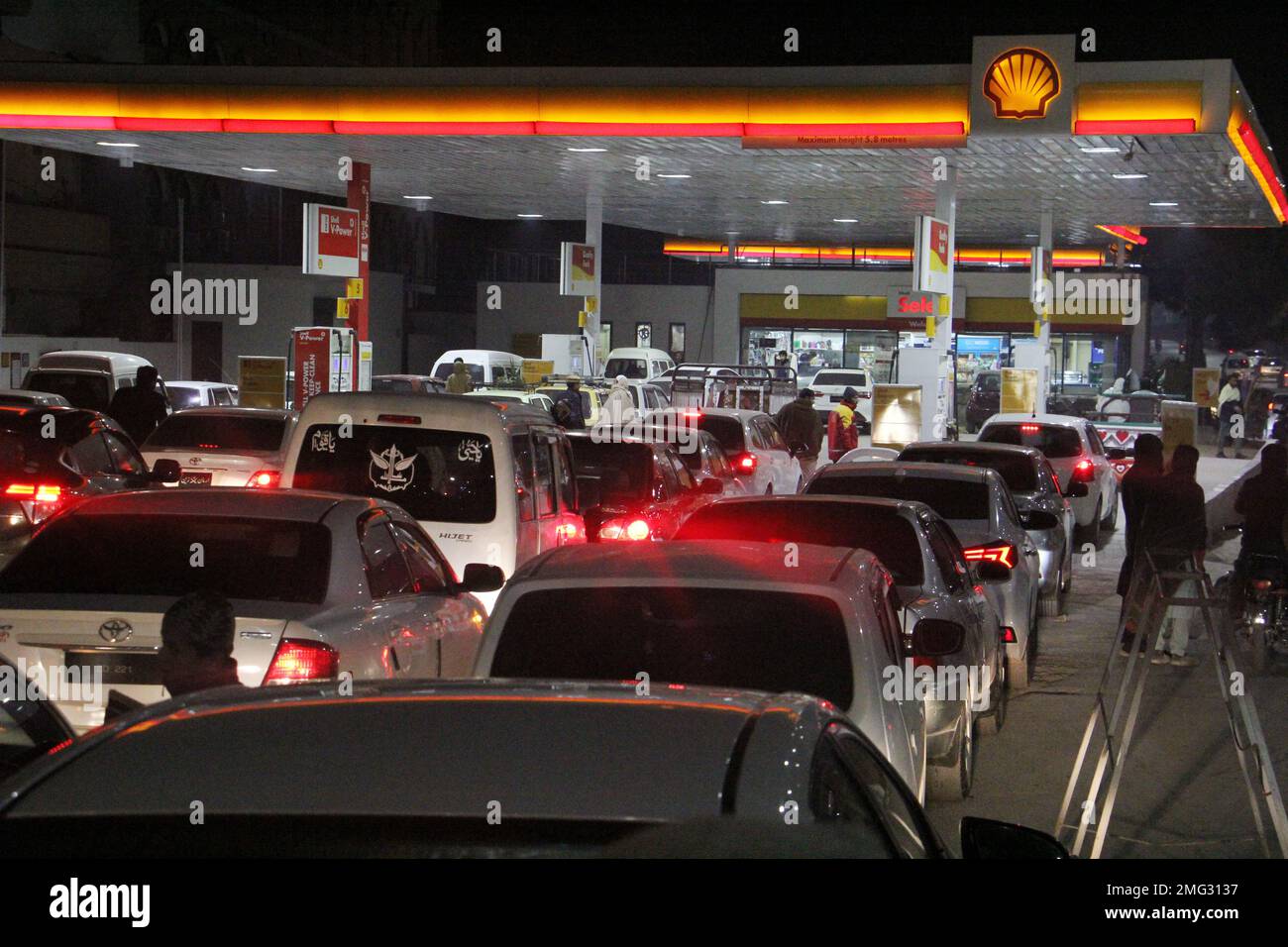 People wait for their turn to get fuel at a petrol station, a day after ...