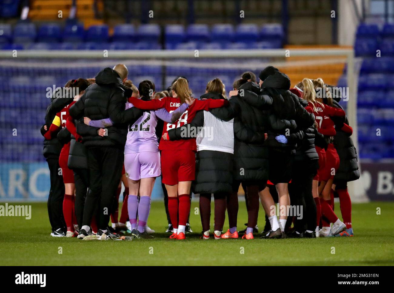 Liverpool players and staff members huddle together on the pitch at the ...