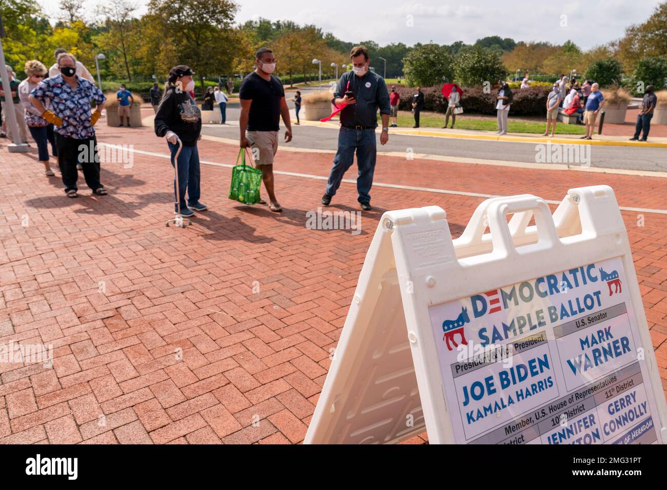 A Democratic sample ballot is on display next to a line stretching the ...