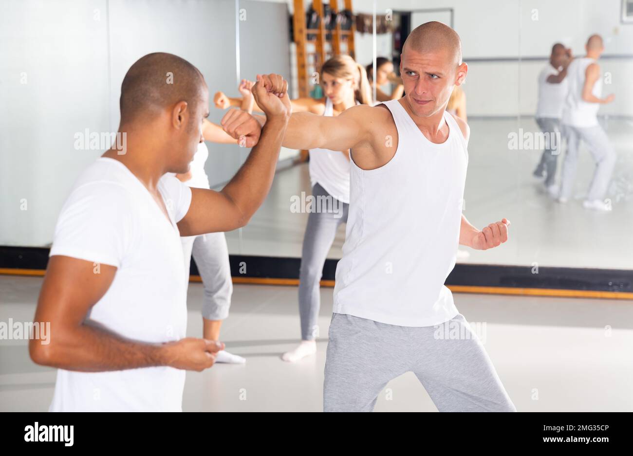 Men practicing basic moves during self defense course at gym Stock ...
