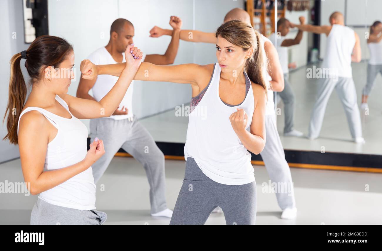 Two young women practicing basic self defense skills at gym Stock Photo ...