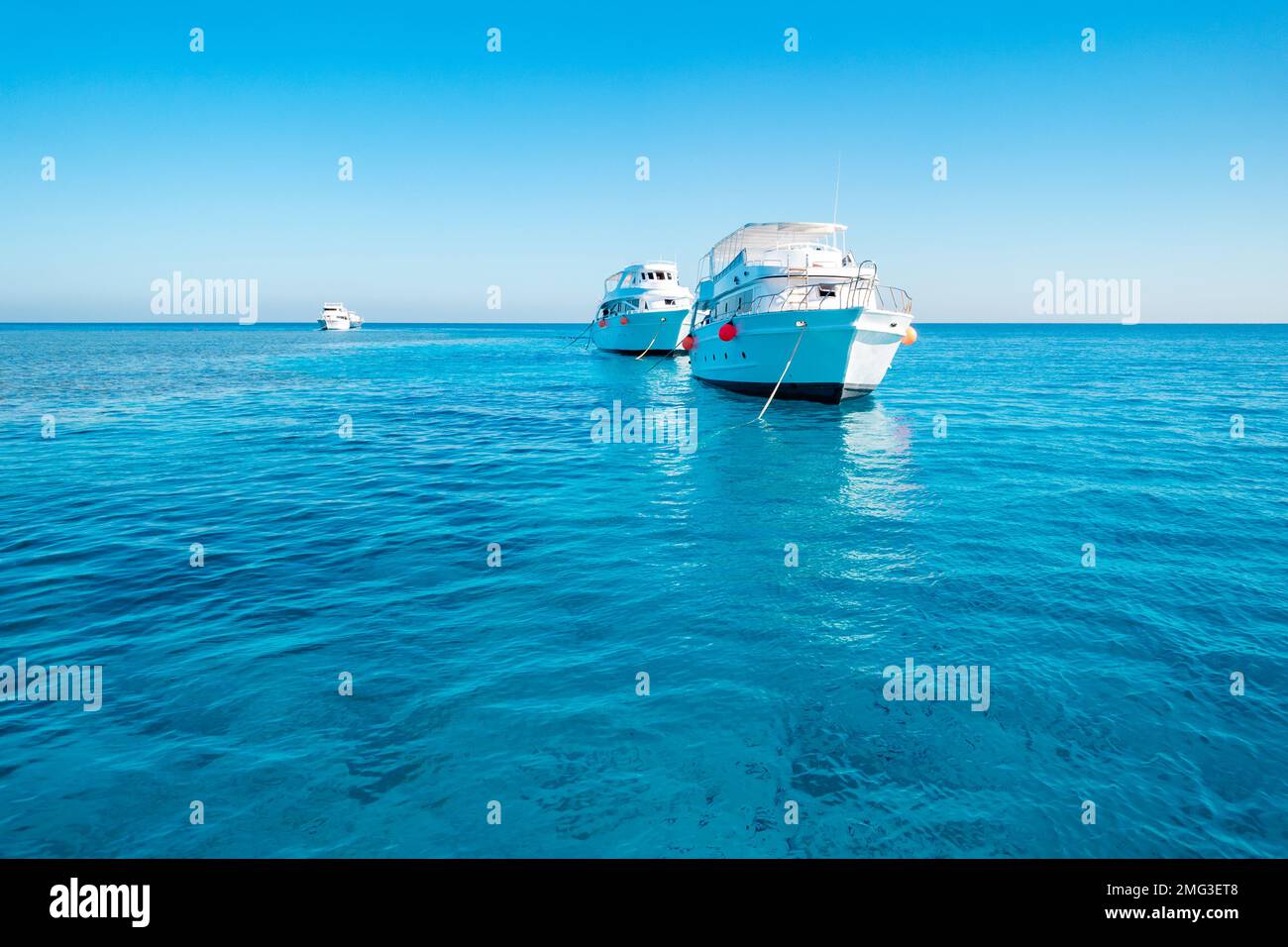 Sea excursion on white yachts. The ships are standing in a blue ...