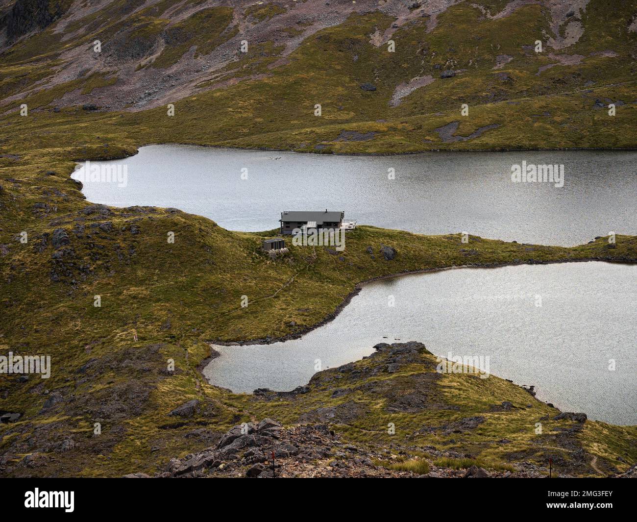 Scenic mountain panorama of idyllic alpine Angelus Hut on lake shore in ...