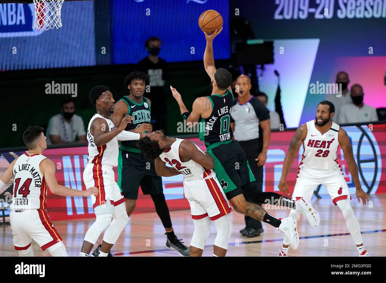 Boston Celtics' Jayson Tatum (0) takes a shot over Miami Heat's Jimmy Butler (22) as Tyler Herro ...