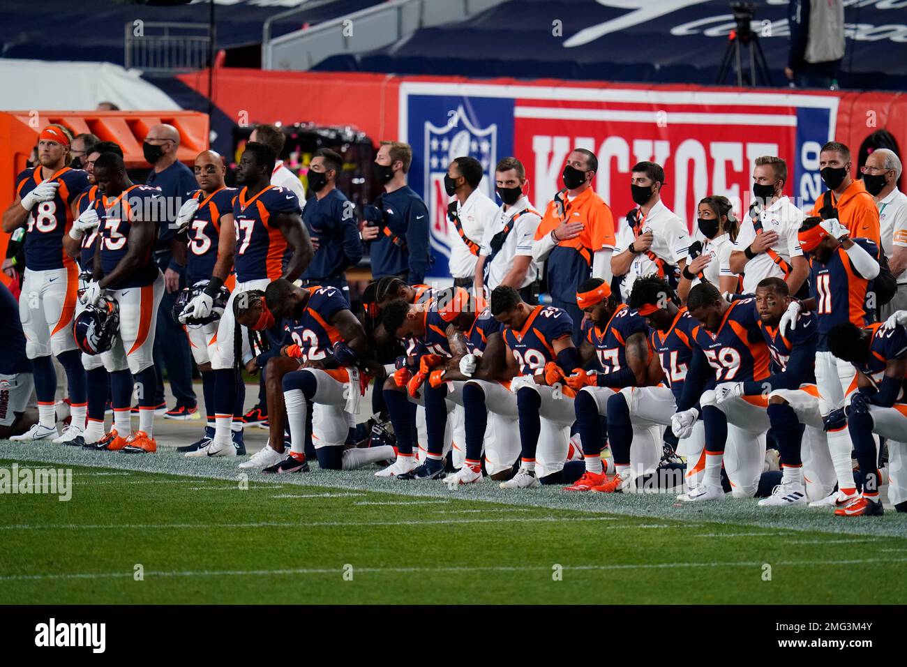 Members of the Denver Broncos kneel and stand during the national ...