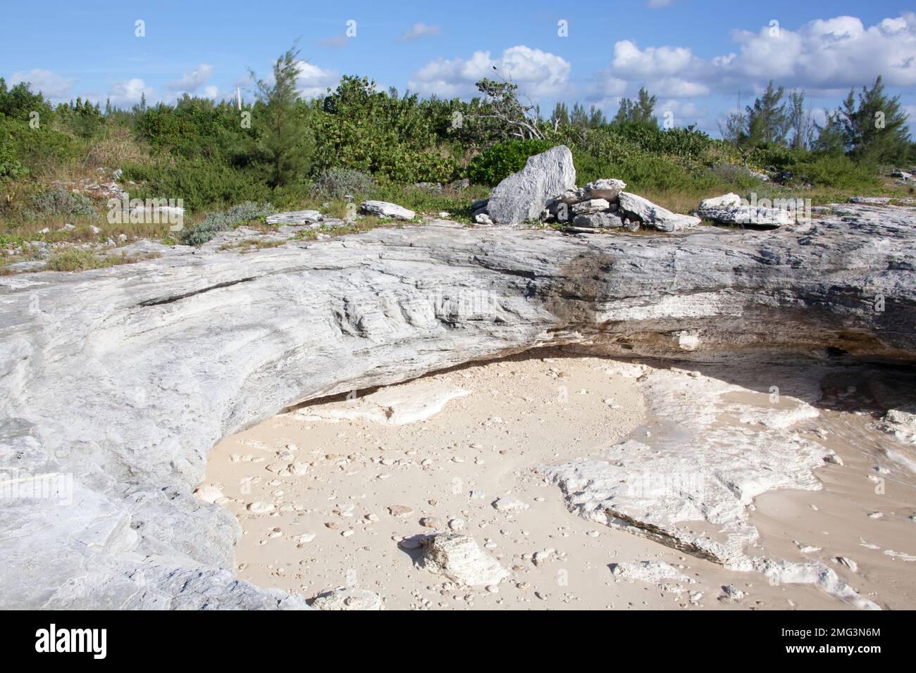 The scenic view of a small circular beach surrounded by eroded rocky ...