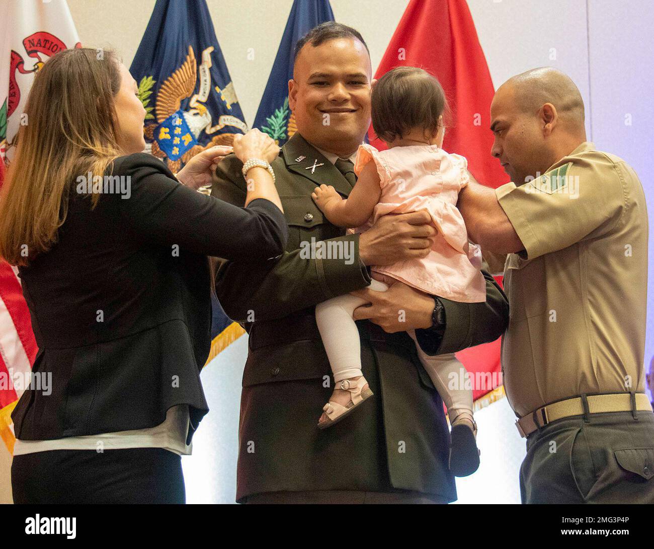 2nd Lt. Sashi Alam of Chicago has his new rank pinned on by his spouse ...