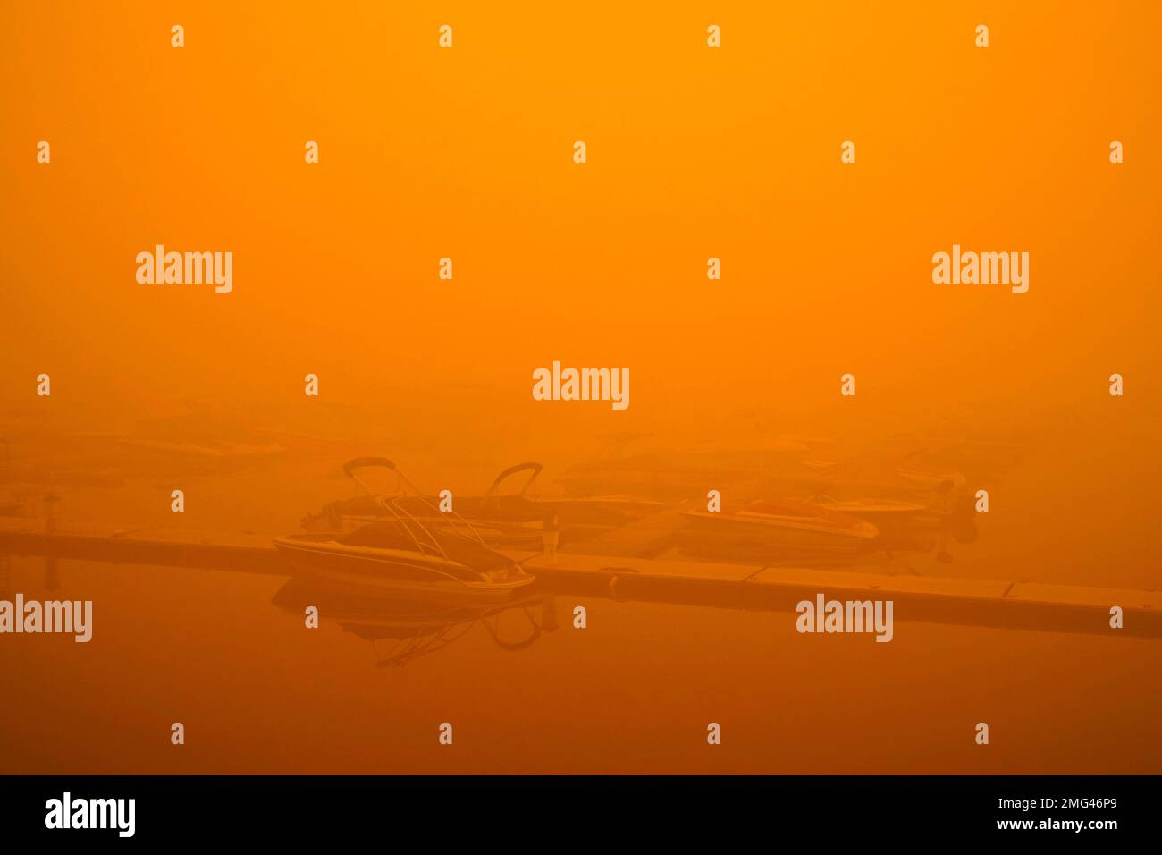 Boats are partially obscured by smoke from a wildfire at a marina on ...