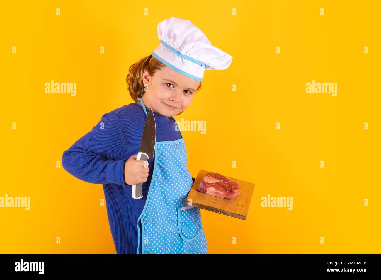 Kid cook hold cutting board with meat beef steak and knife. Cooking ...