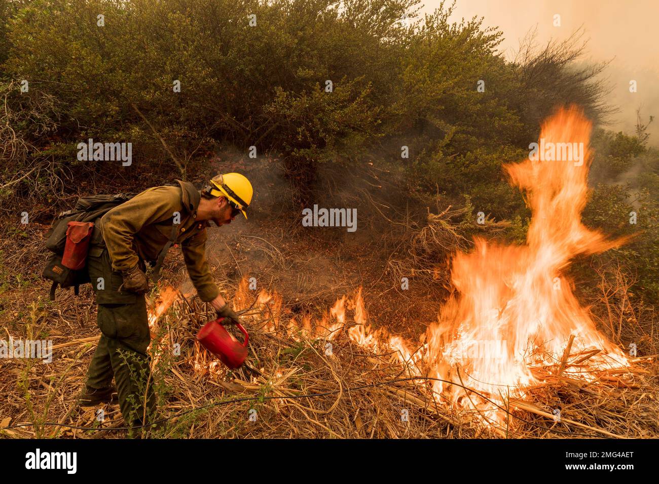 A firefighter with Vandenberg Air Force Base, lights a back burn to ...