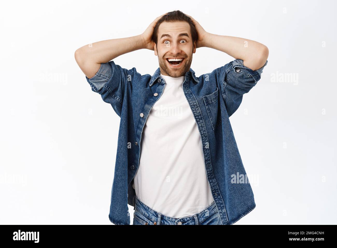 Image of guy looks happy and surprised, receive great news, smiles with ...