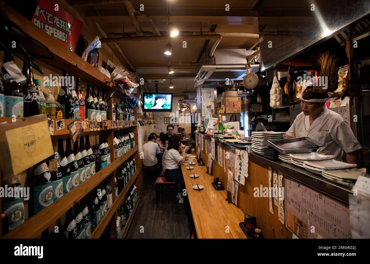 Customers spend time at an izakaya restaurant in Tokyo's Shimo Kitazawa ...