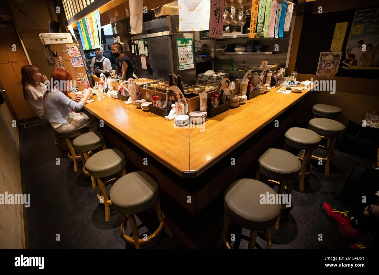 Customers spend time at an izakaya restaurant in Tokyo's Shimo Kitazawa ...
