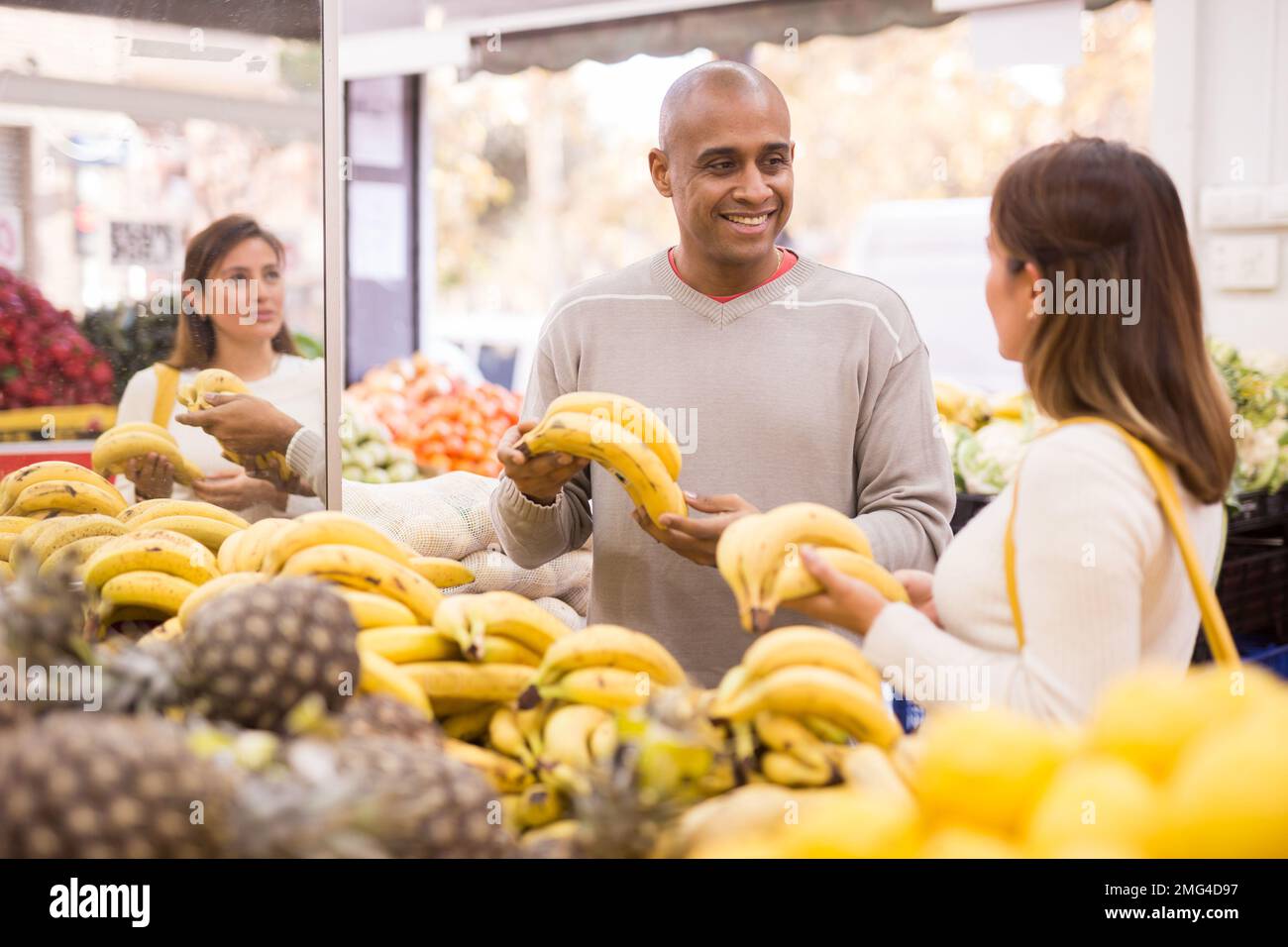 Married couple picks and buys ripe bananas in the vegetable section of ...
