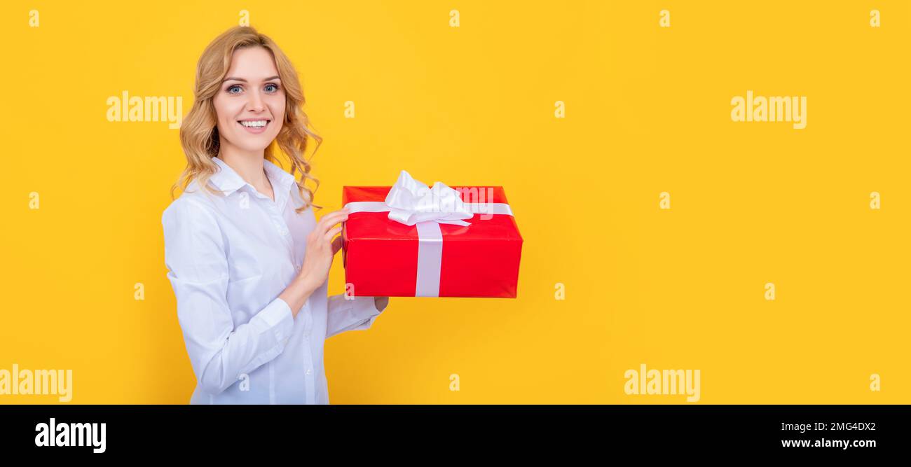happy woman hold big present box on yellow background. Woman isolated ...