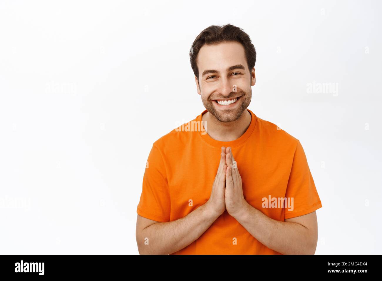 Thank you. Smiling happy guy shows namaste, thanks gesture, bowing at ...