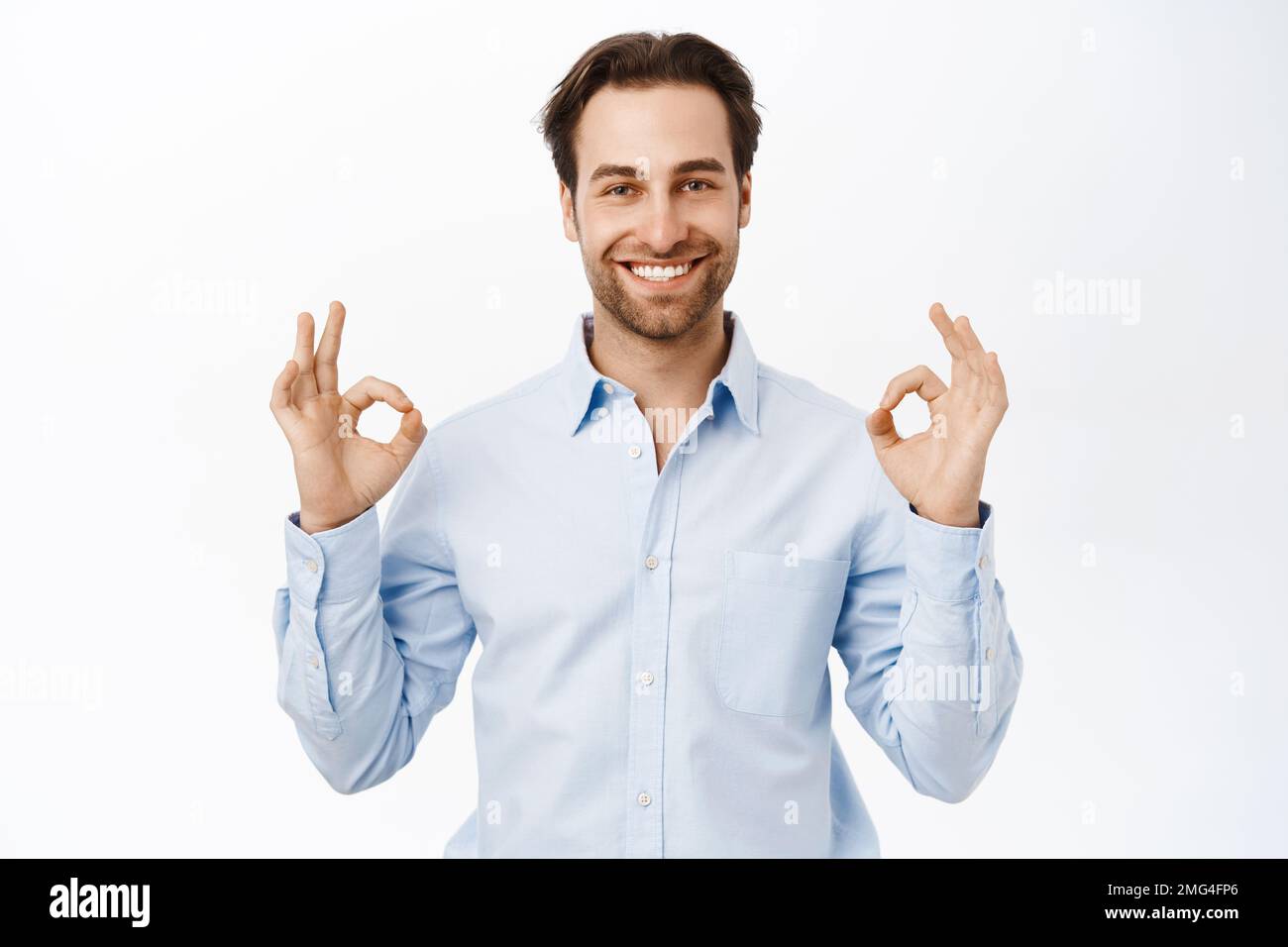 Confident smiling businessman, salesman shows okay, ok sign in approval ...