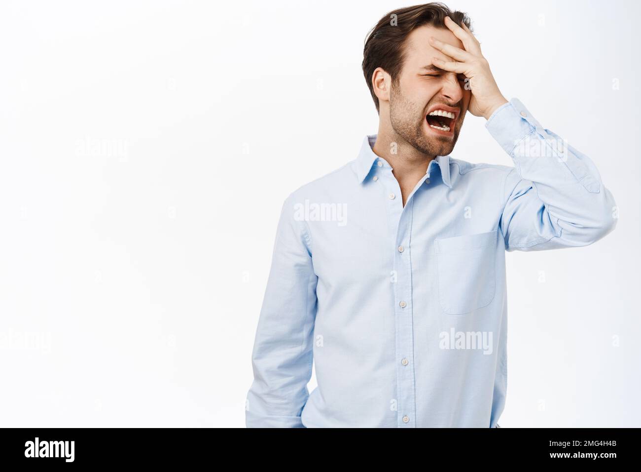 Frustrated man grieving, screaming and holding hand on head ...