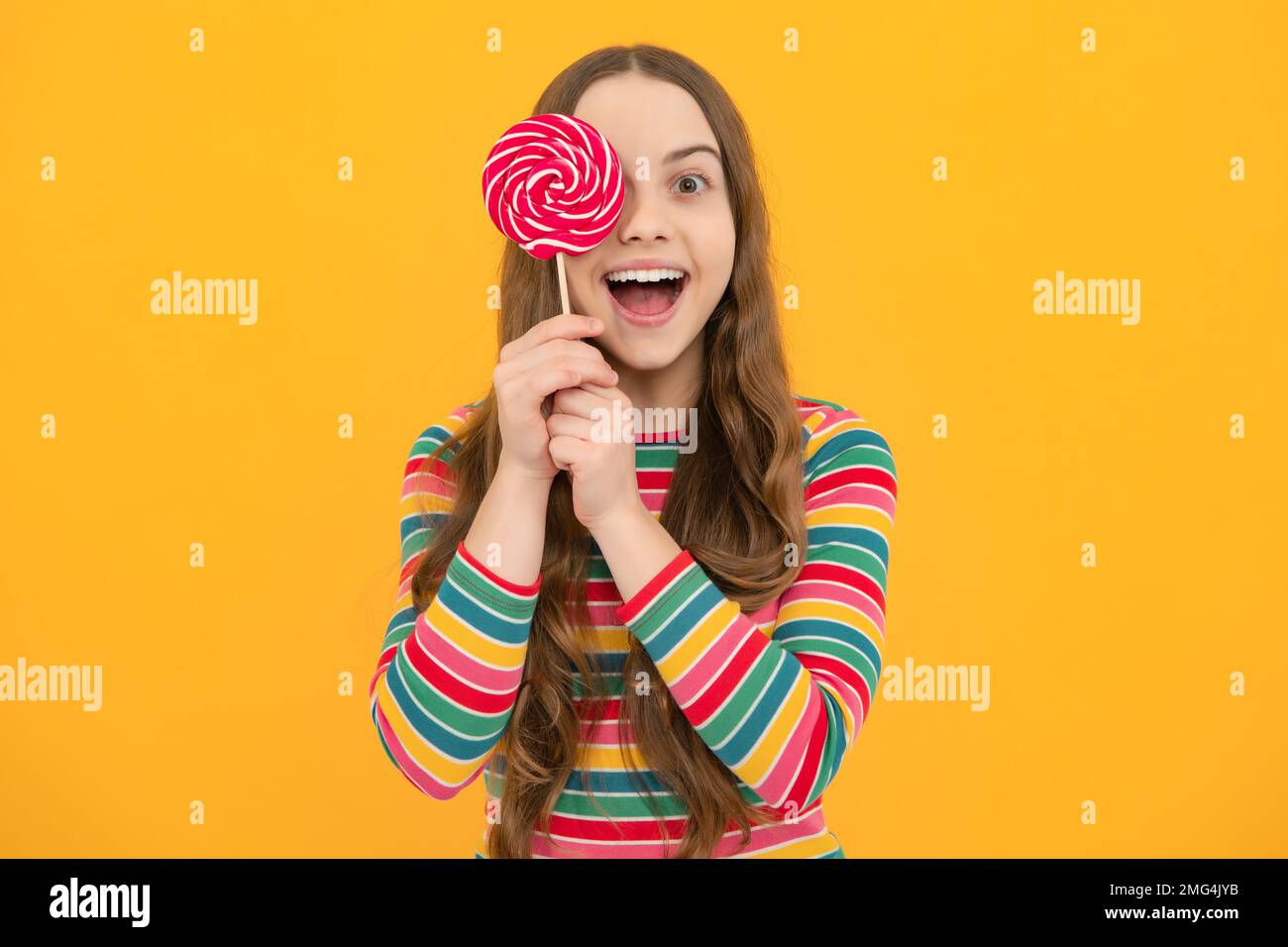 Cool teen child with lollipop over yellow isolated background. Sweet ...