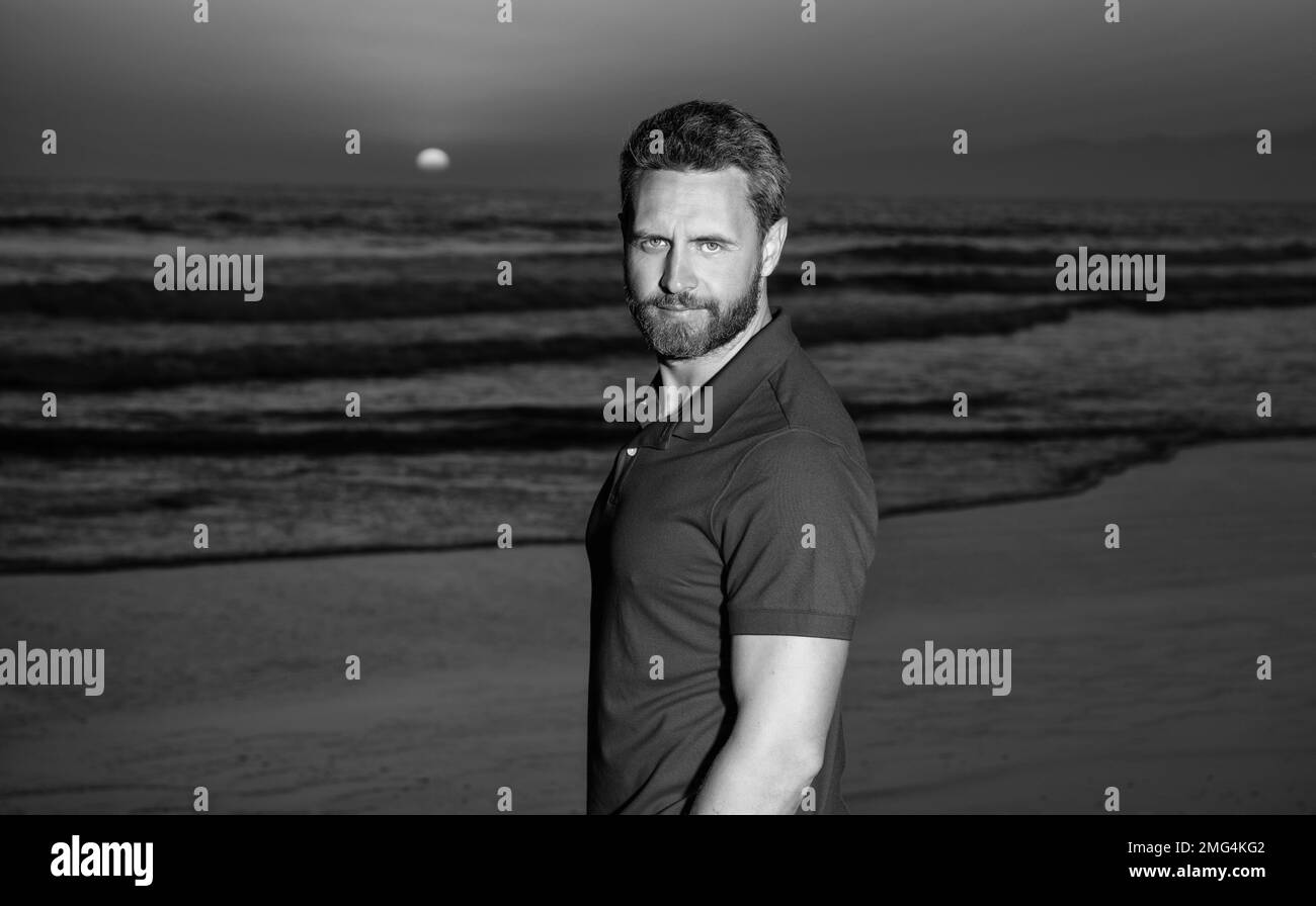 man portrait with beard in sunset over sea. unshaven guy on beach ...