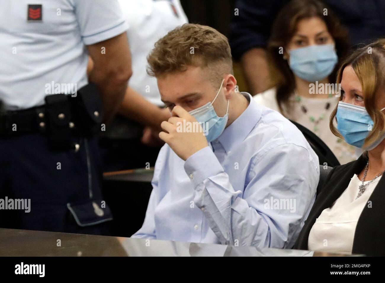 American tourist Finnegan Lee Elder, center, adjusts his face mask ...