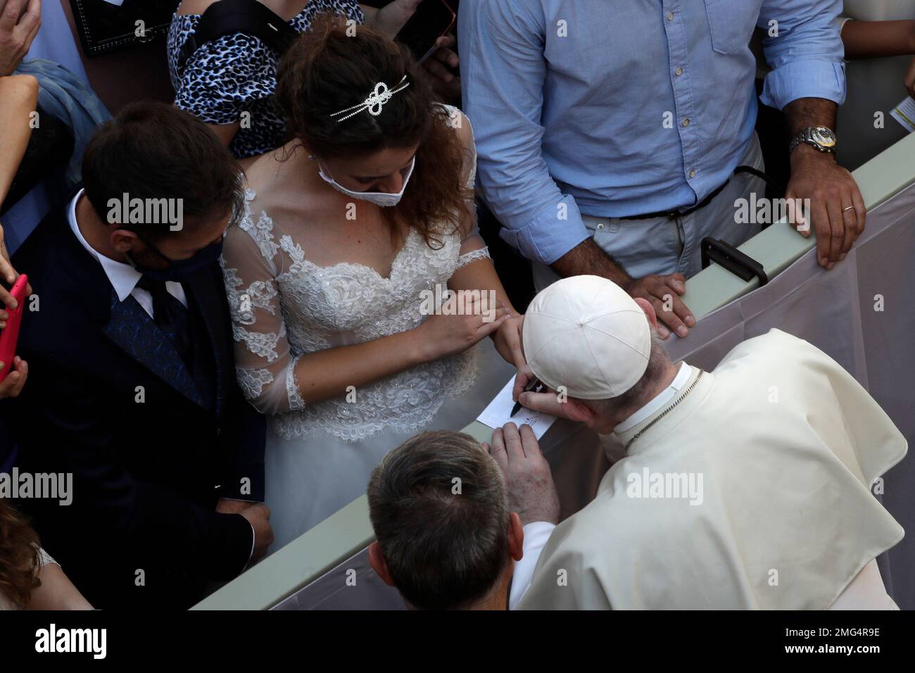 Pope Francis signs a card for a young couple during his weekly general ...