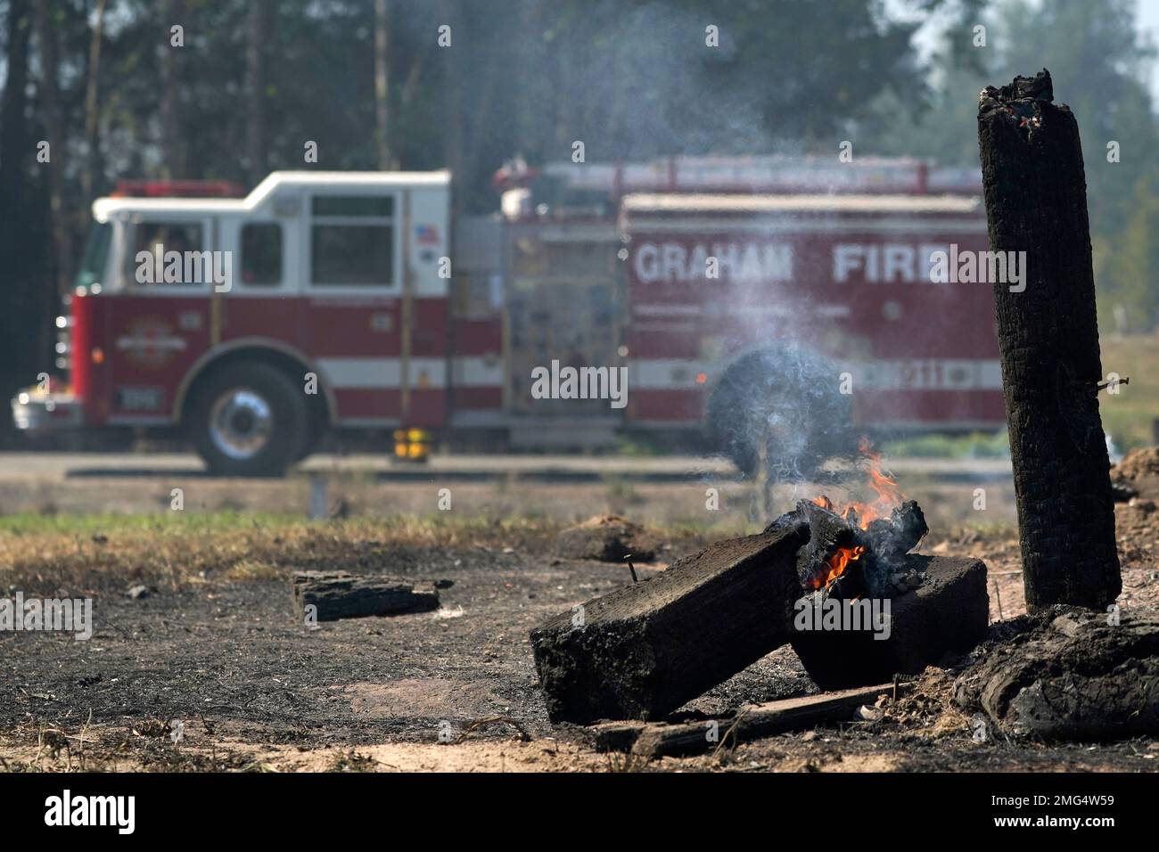 A post burns in front of a Graham Fire Dept. truck, Tuesday, Sept. 8 ...