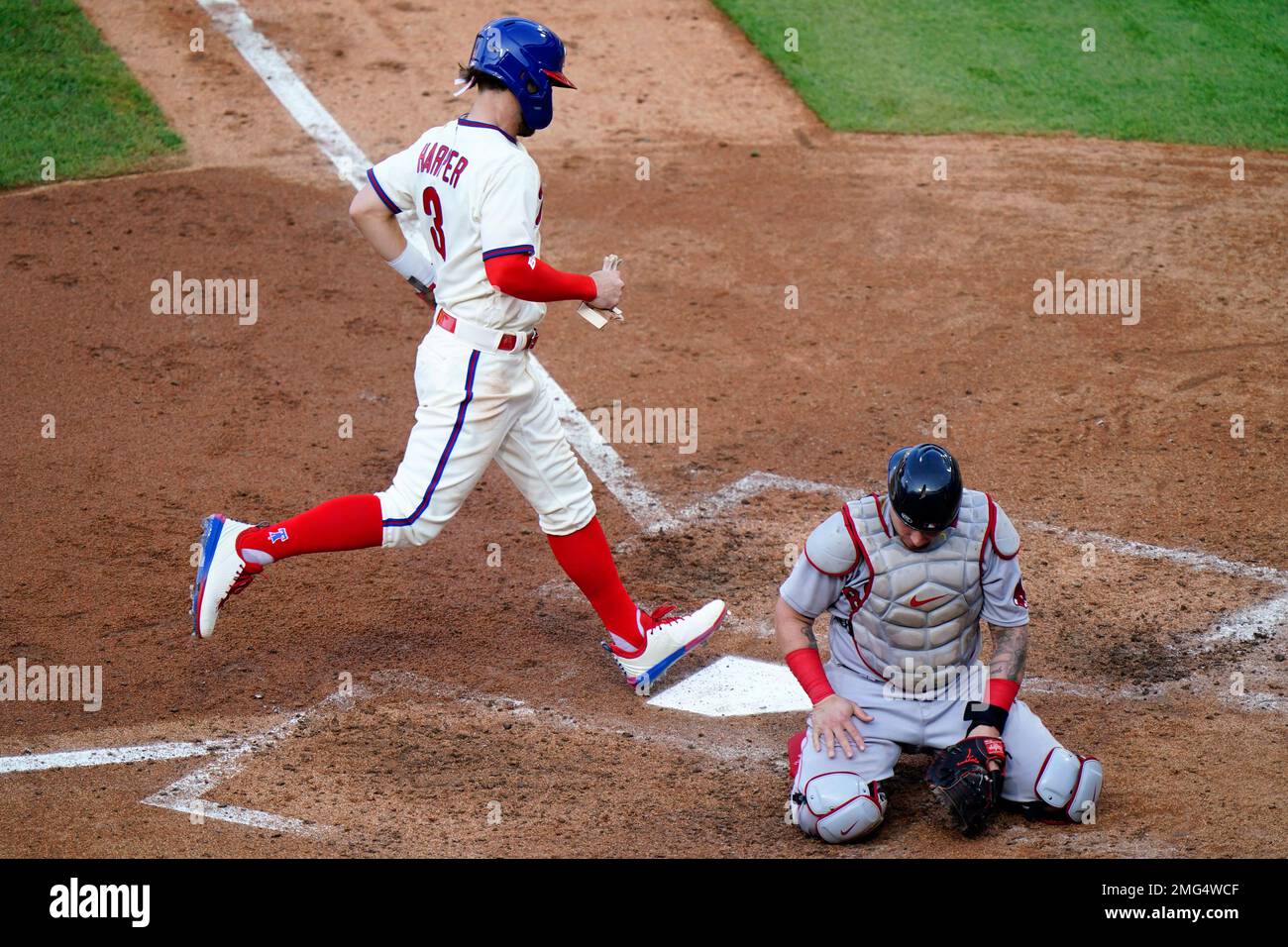 Philadelphia Phillies' Bryce Harper, left, scores past Boston Red Sox catcher Christian Vazquez ...