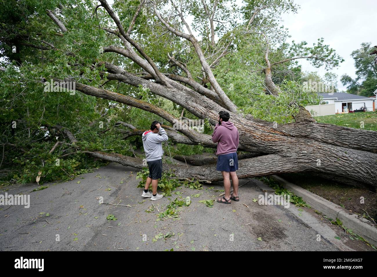 People survey the damage after high winds caused widespread damage and ...