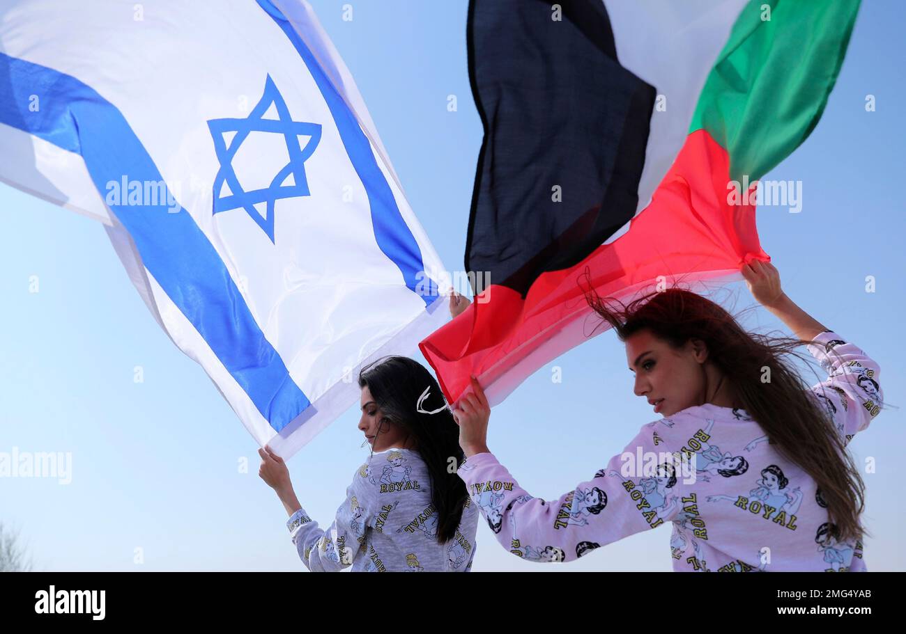 Israeli model May Tager, left, holds Israel's blue-and-white flag ...