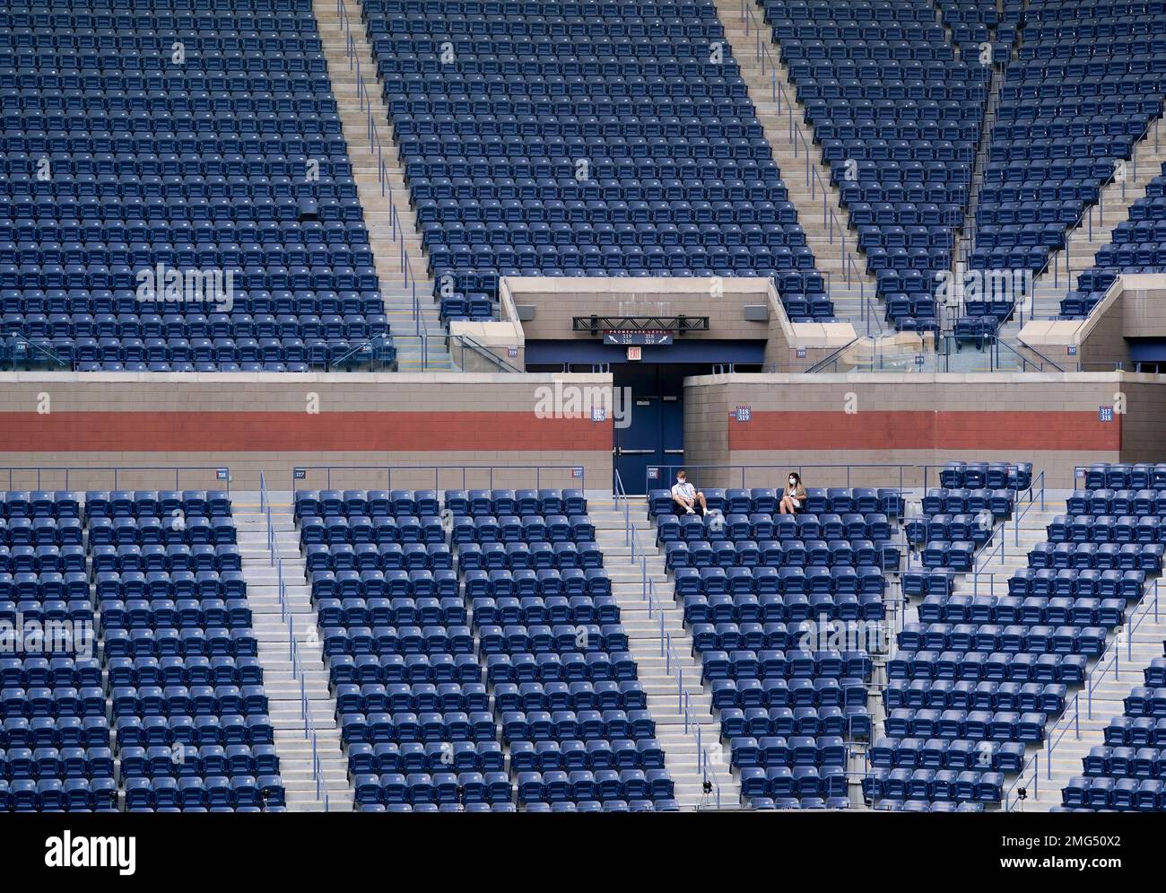 A tennis player and USTA staff member watch play inside Arthur Ashe ...