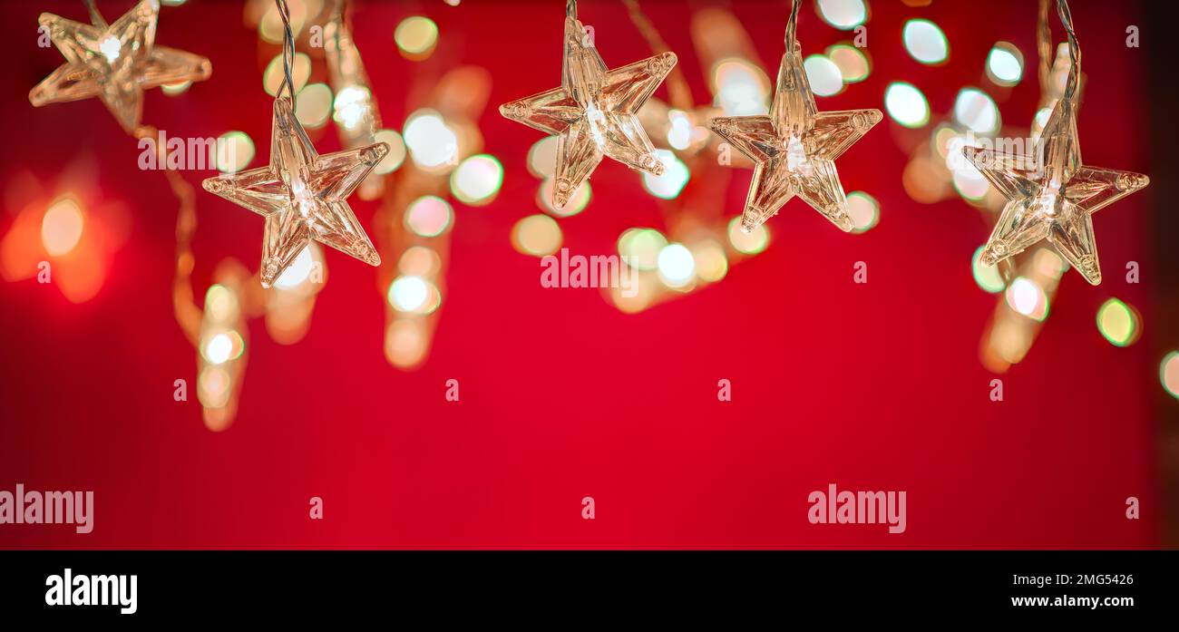 String of star shaped Christmas lights on red background. Holiday ...
