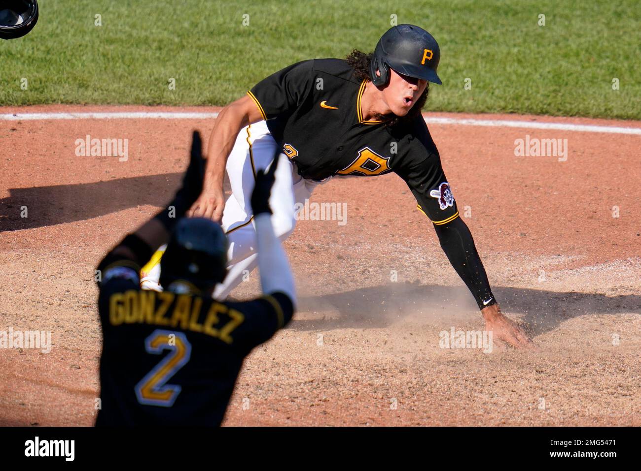 Pittsburgh Pirates' Cole Tucker, right, scores on a sacrifice fly to ...