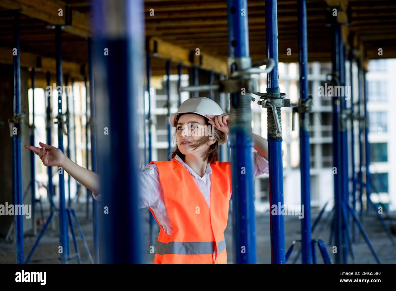 Confident Female builder checks fastenings on a monolithic structure ...