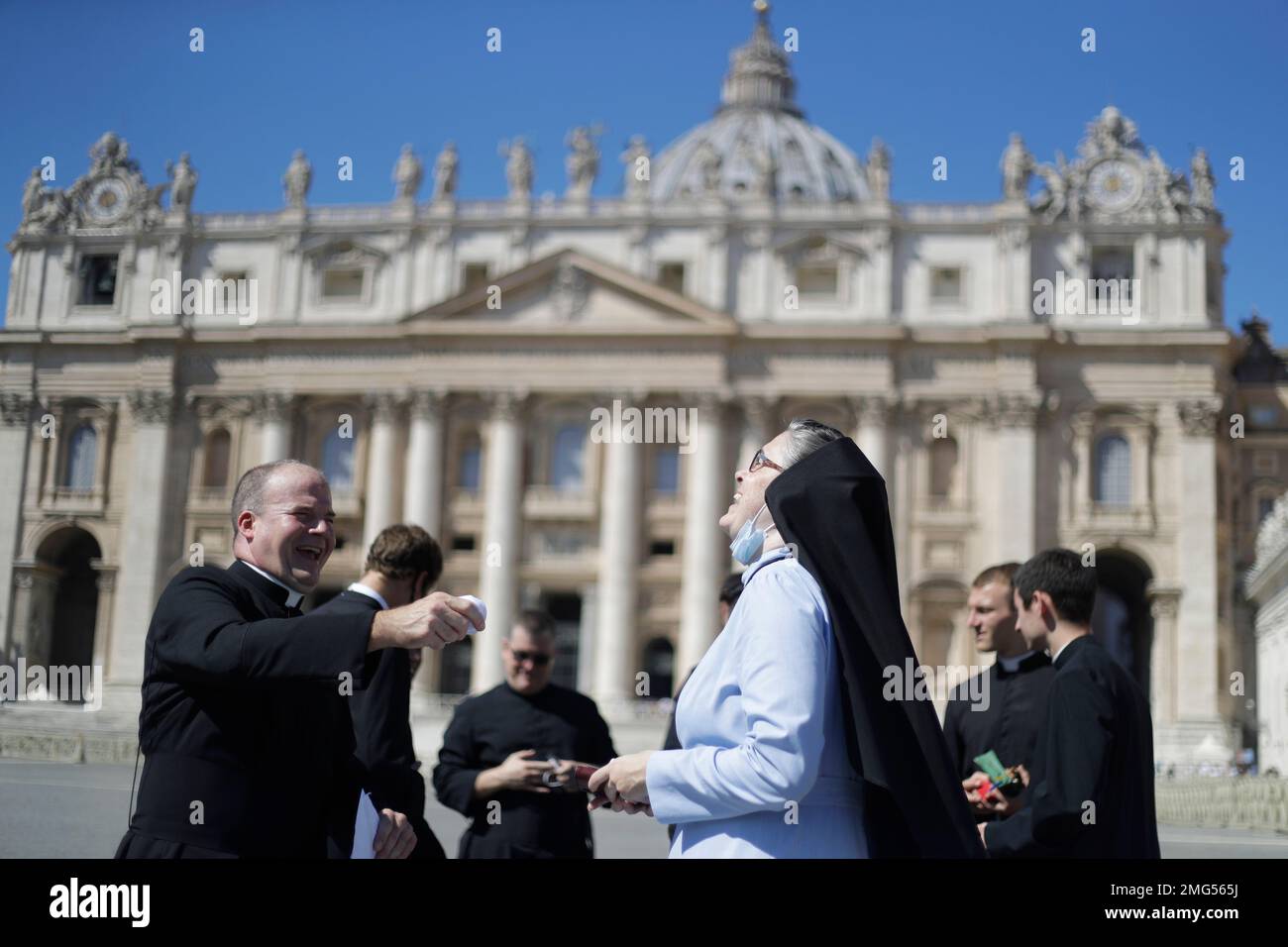 A priest and a nun share a laugh as they wait for Pope Francis to ...
