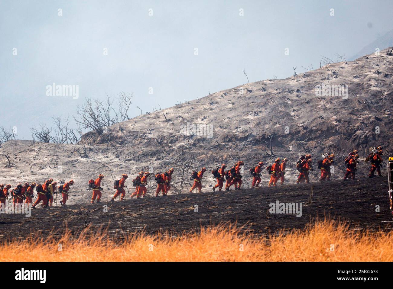 Members of a hand crew work on the fire line in Yucaipa, Calif ...