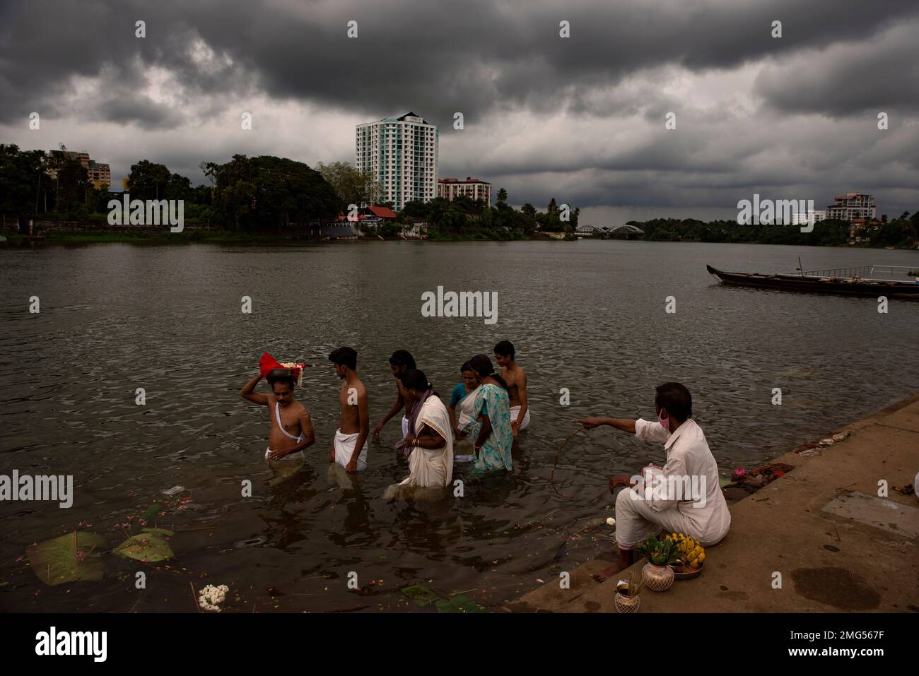 A man wearing a mask as a precaution against the coronavirus sits and ...
