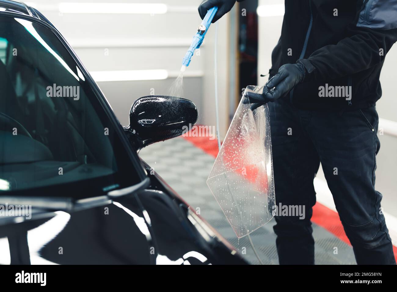Man wearing work clothes and black gloves preparing side car mirror for ...