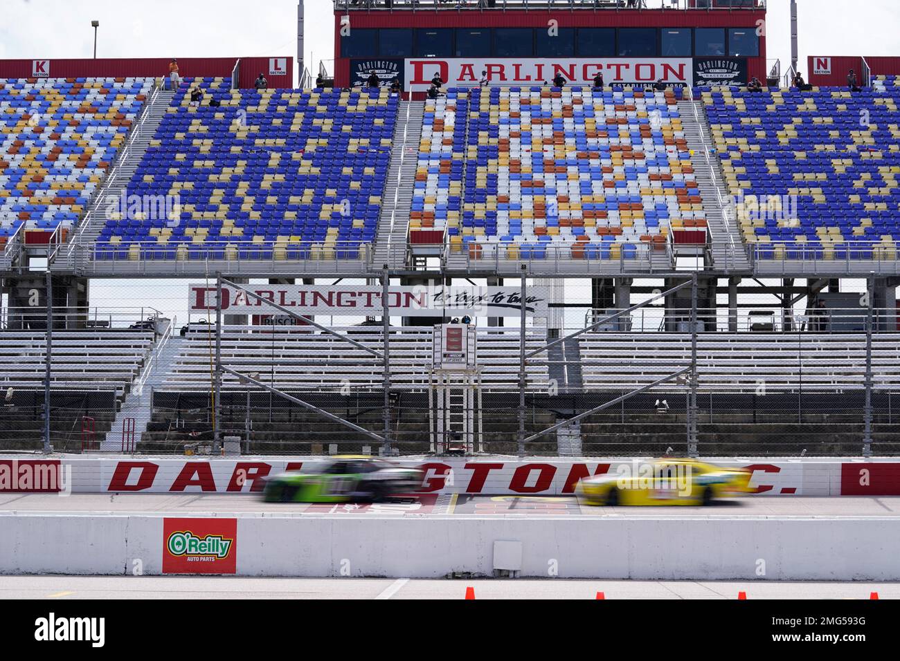 Cars move by empty stands during a NASCAR Xfinity Series auto race ...