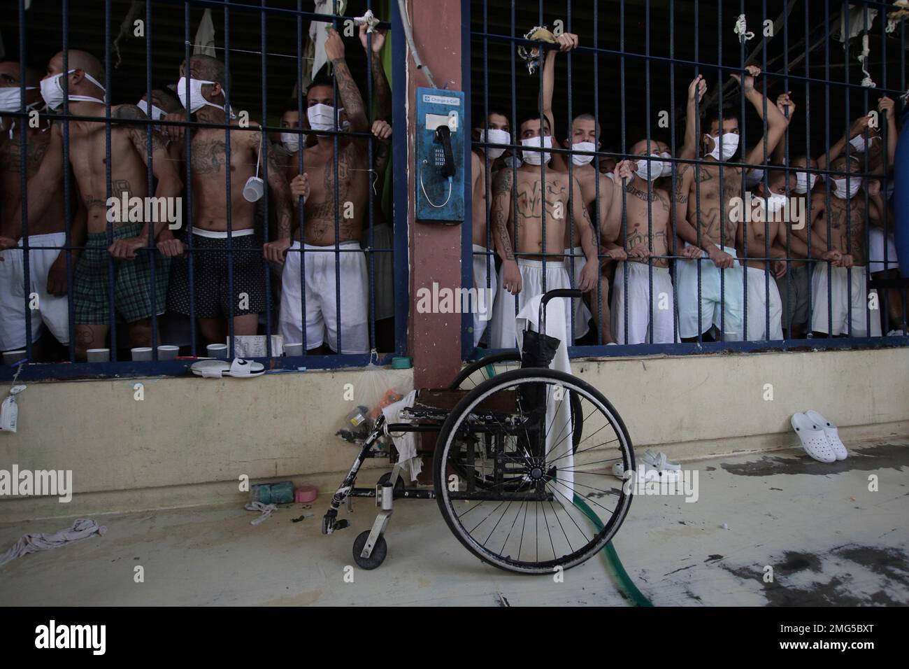 Imprisoned gang members, wearing protective face masks, look out from ...