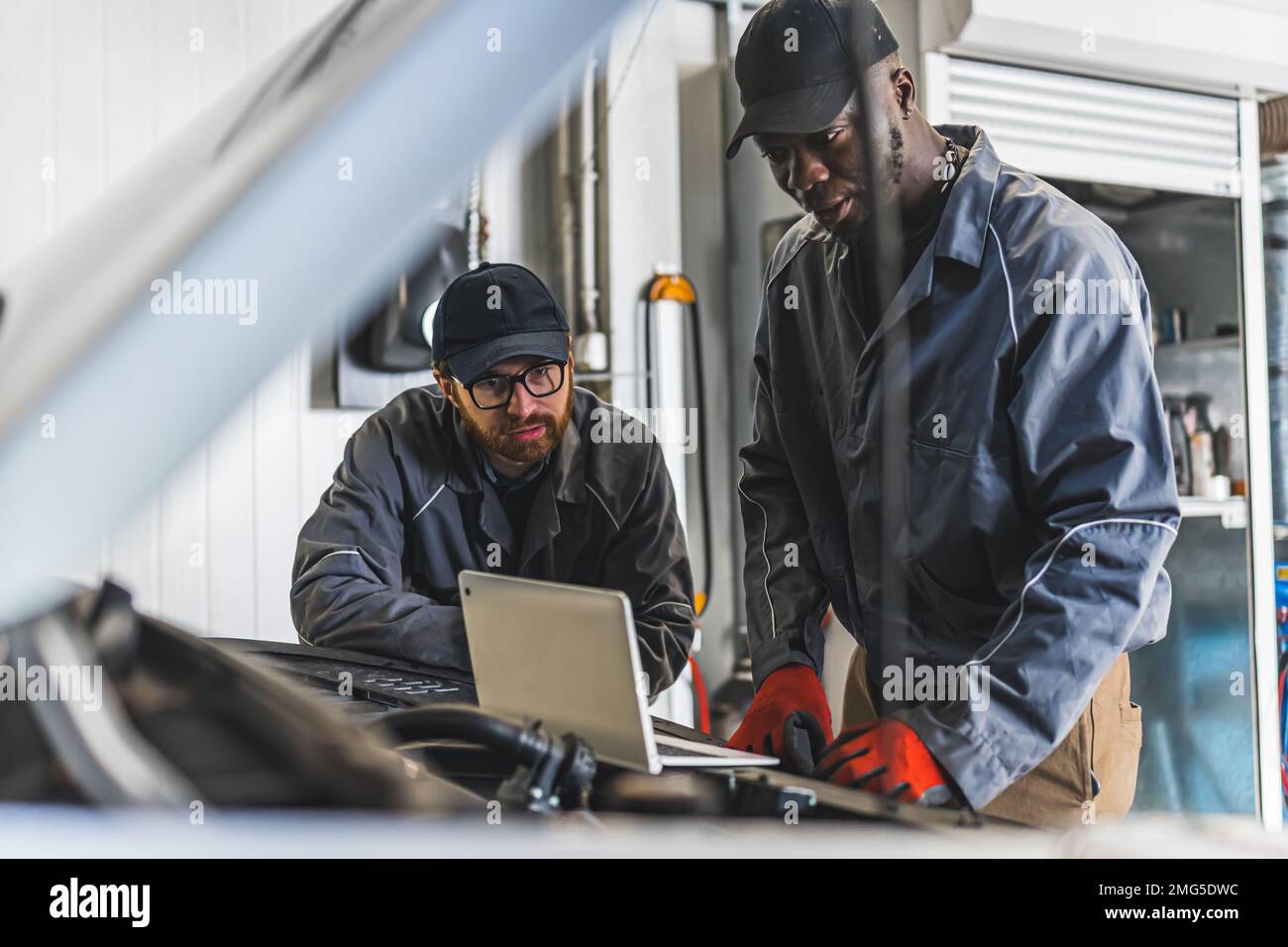 Medium shot of a mechanic during a computer diagnostics with his ...