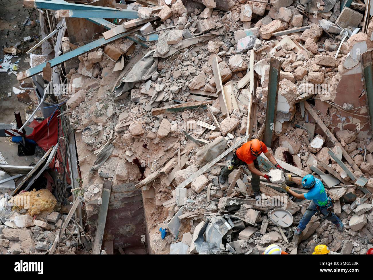 Lebanese and Chilean rescuers search in the rubble of a collapsed ...