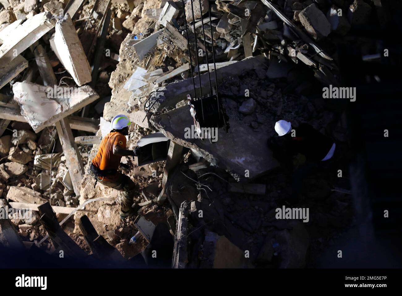 Lebanese and Chilean rescuers searching in the rubble of a collapsed ...