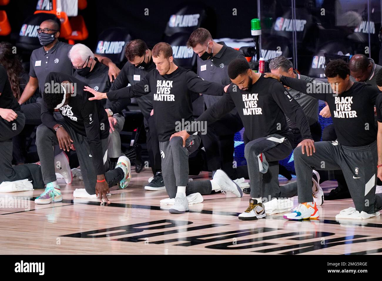Toronto Raptors team members kneel during the national anthem before an ...